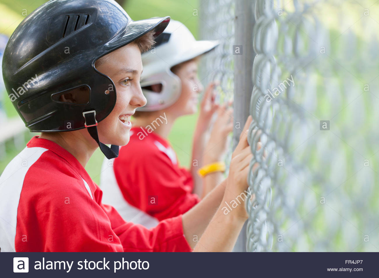 Two young male baseball players watching game from fence Stock Photo ...