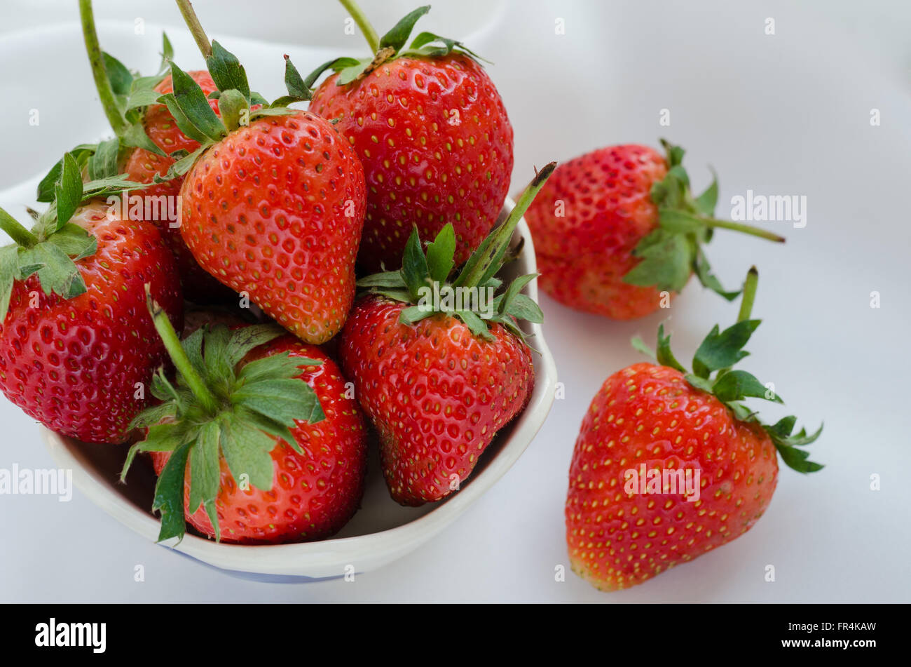Strawberries In Bowl On White Fabric Background Stock Photo - Alamy