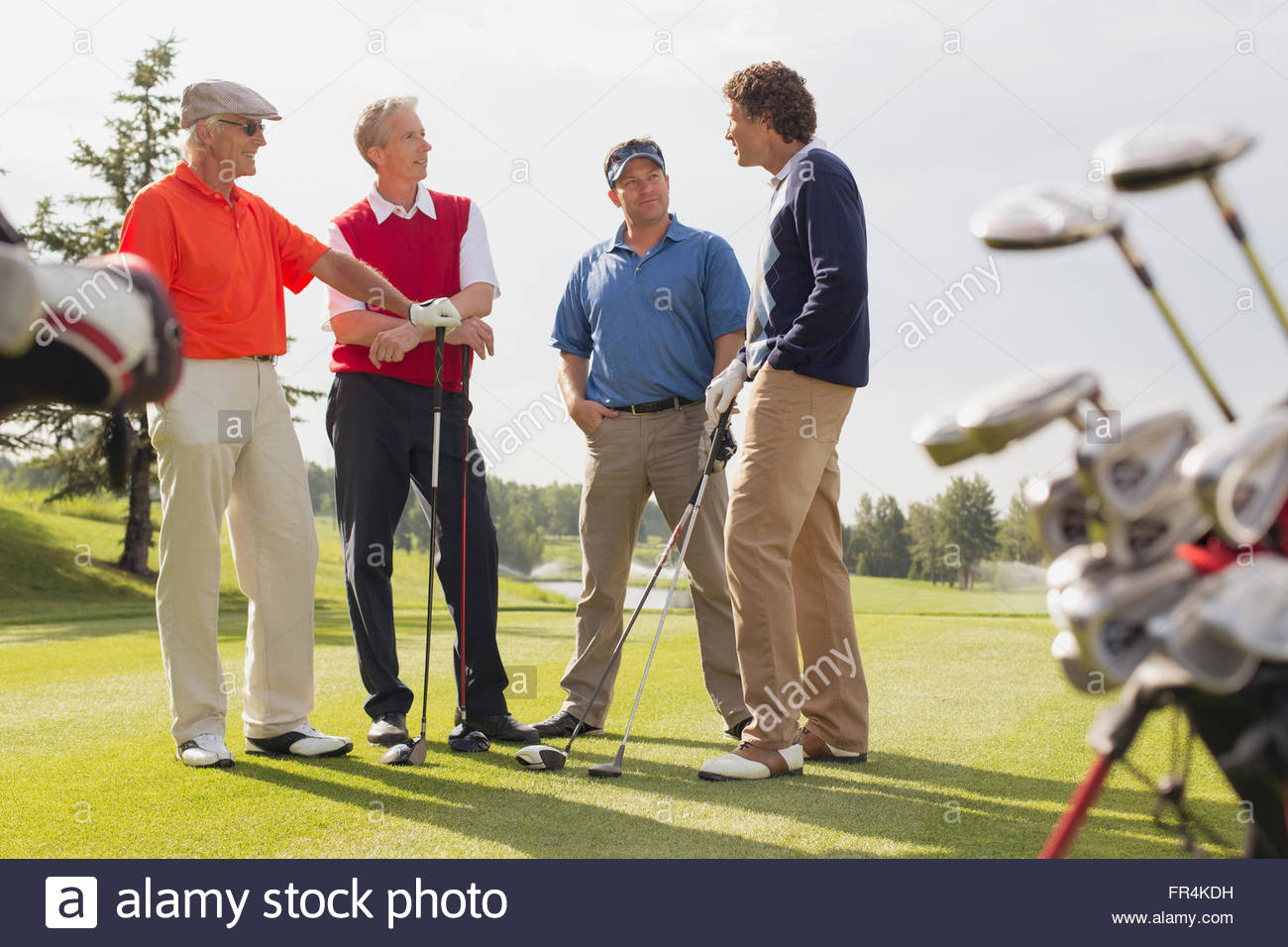 golfing foursome having a conversation on golf green Stock Photo - Alamy