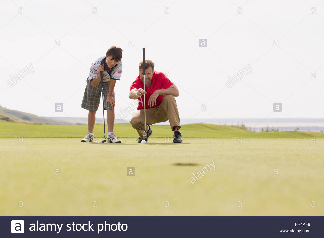 father giving son advice on putting Stock Photo - Alamy