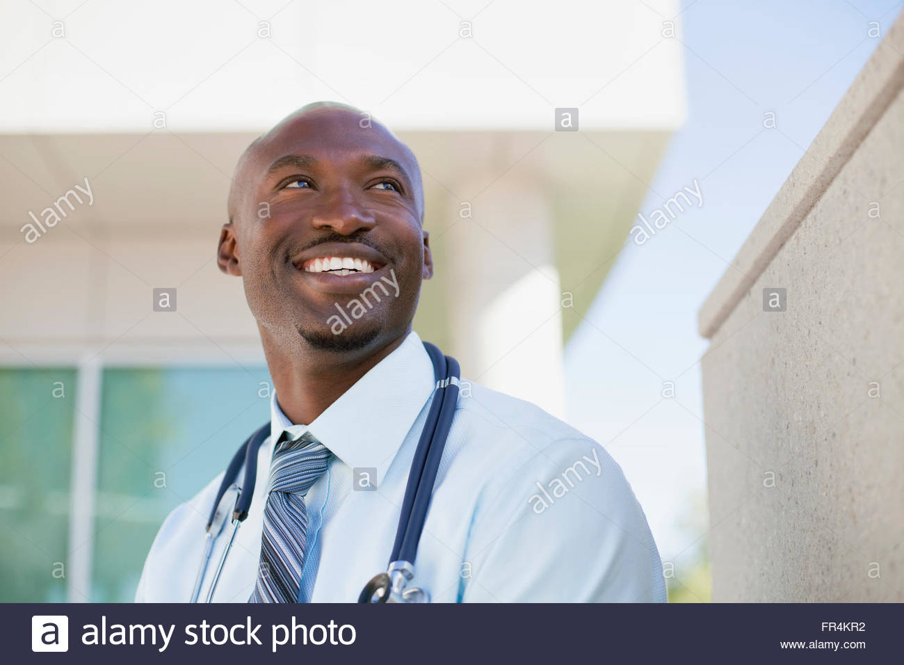 african american doctor standing outside looking up Stock Photo - Alamy