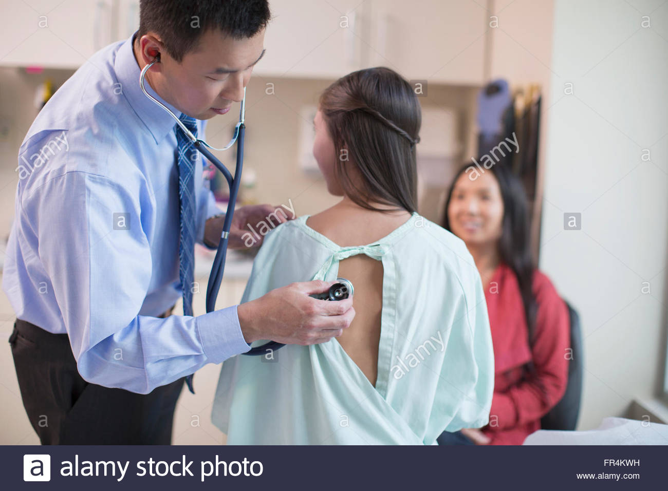 doctor listening with stethescope on teenage girls back Stock Photo - Alamy