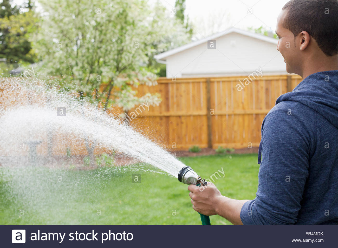 young, homeowner watering the lawn Stock Photo - Alamy