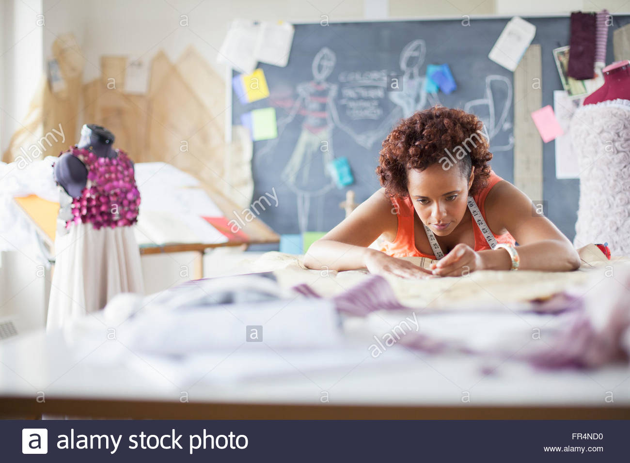 fashion designer pinning pattern to fabric Stock Photo - Alamy
