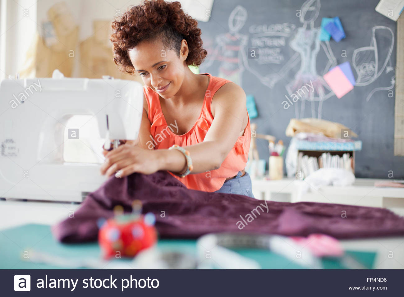 clothing designer using sewing machine in studio Stock Photo - Alamy