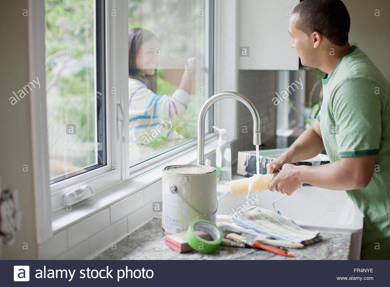 young adult man washing up painting tools Stock Photo - Alamy