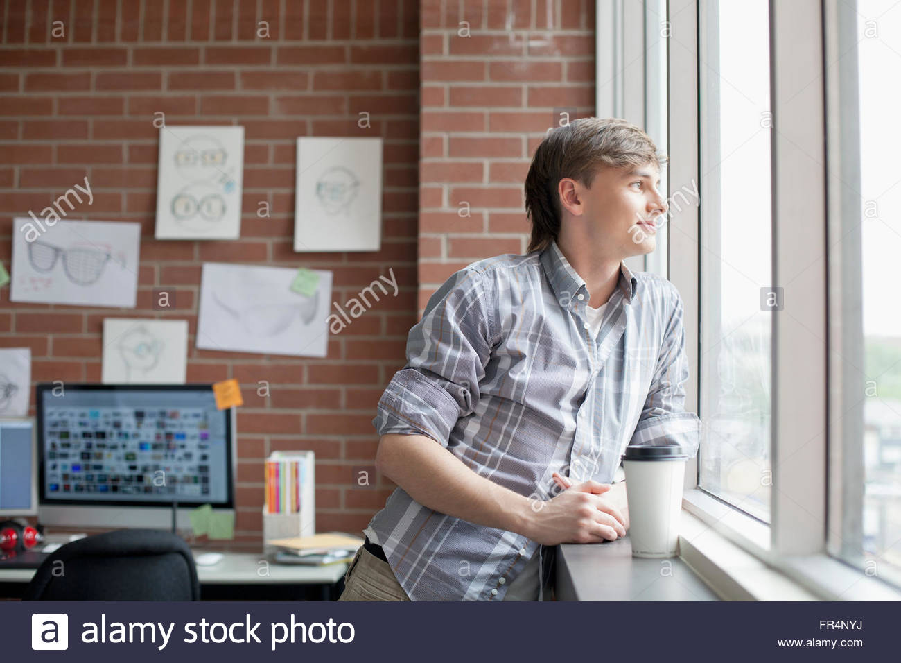 young, male industrial designer gazing out window Stock Photo - Alamy