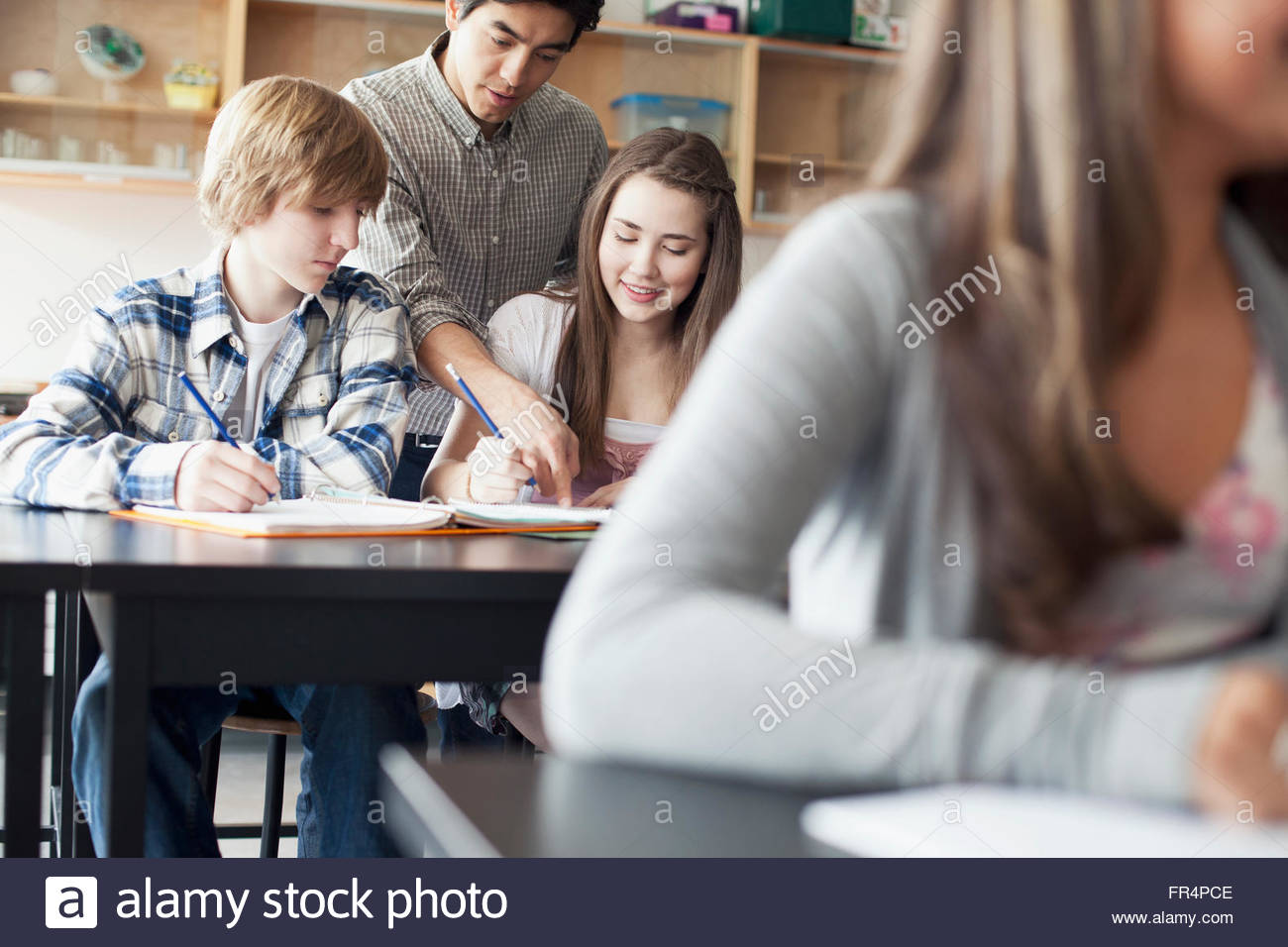 middle school student getting help from teacher Stock Photo - Alamy