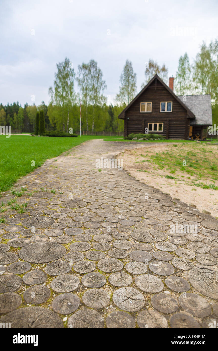 Wooden round log path leading to cottage house, blurred background ...