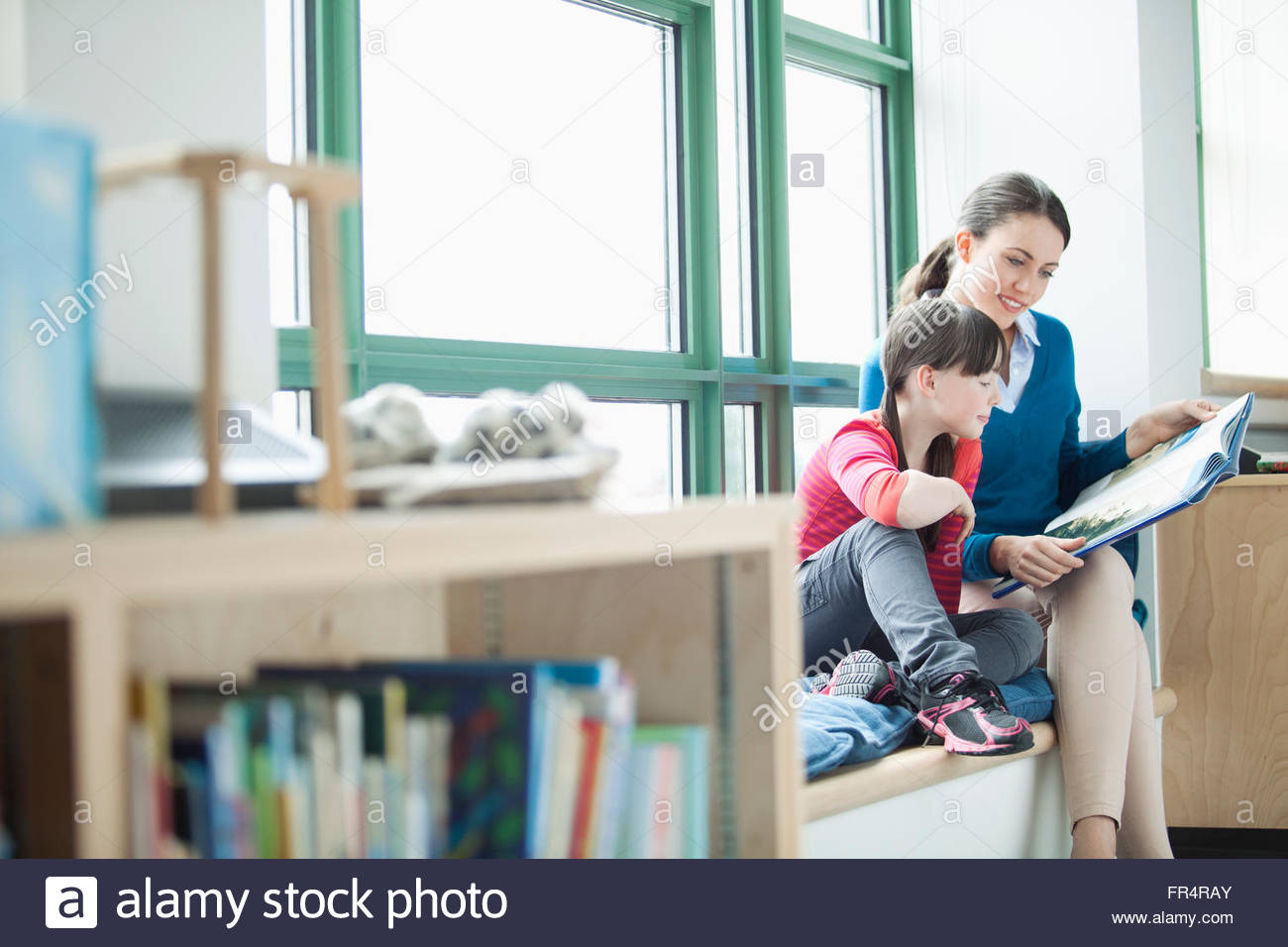 elementary teacher reading with student Stock Photo - Alamy