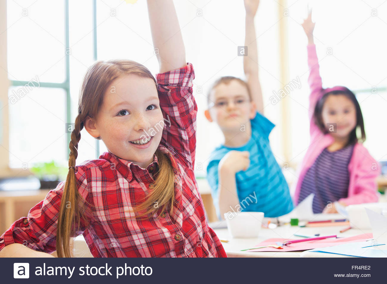 elementary students with arms raised Stock Photo - Alamy