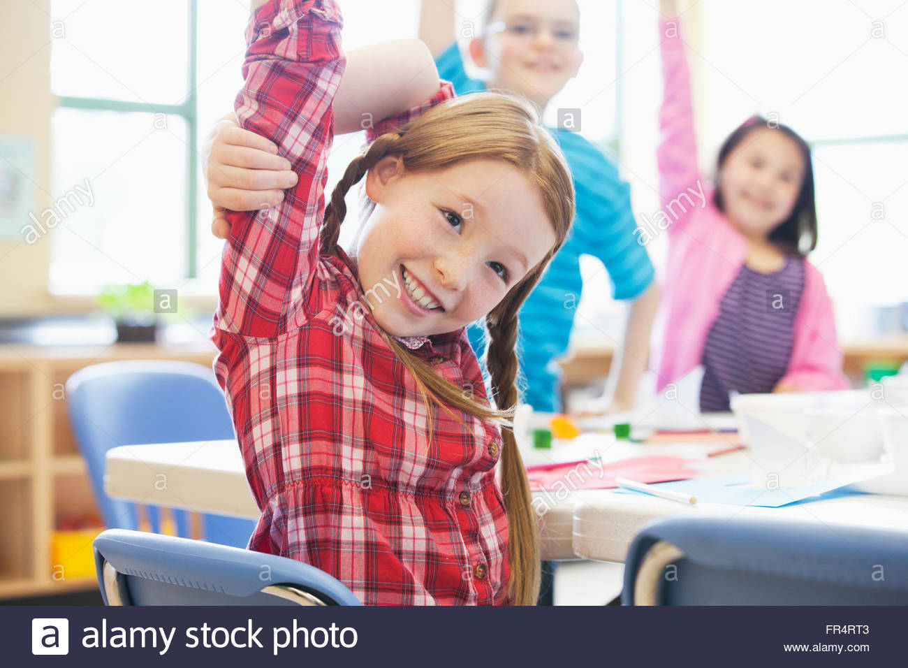 elementary students with arms raised Stock Photo - Alamy
