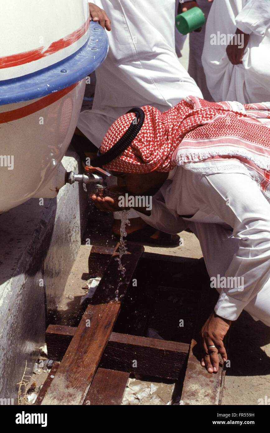 Young Saudi men drinking water from a container at a recruiting center ...