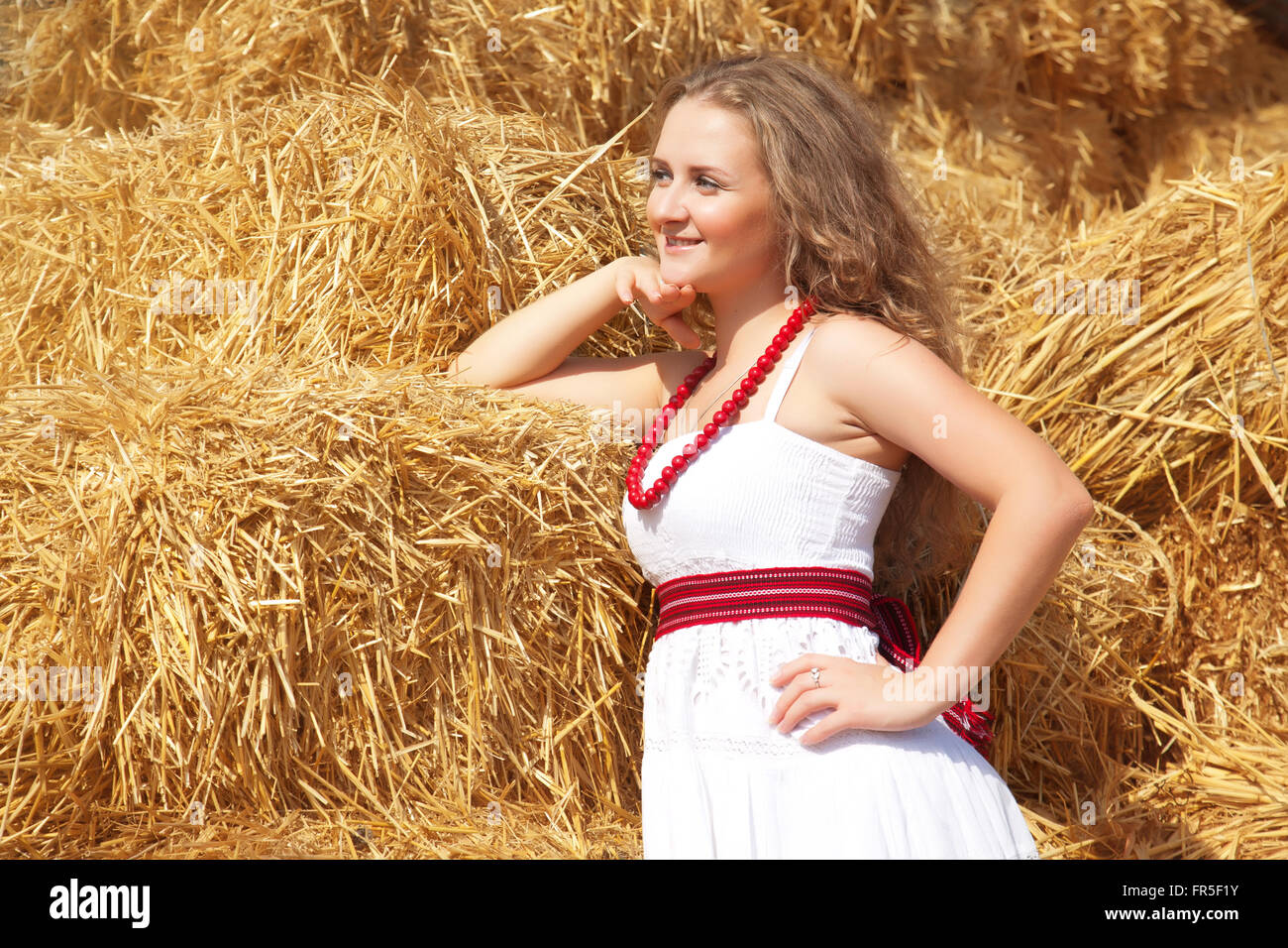 Portrait of a beautiful young woman dressed in country style on a ...