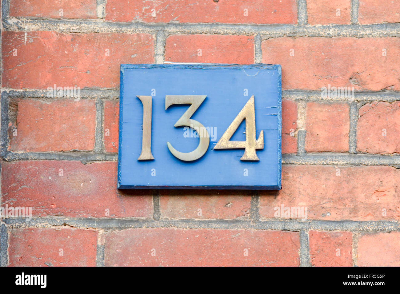 House number 134 sign attached to red brick outside wall Stock Photo ...