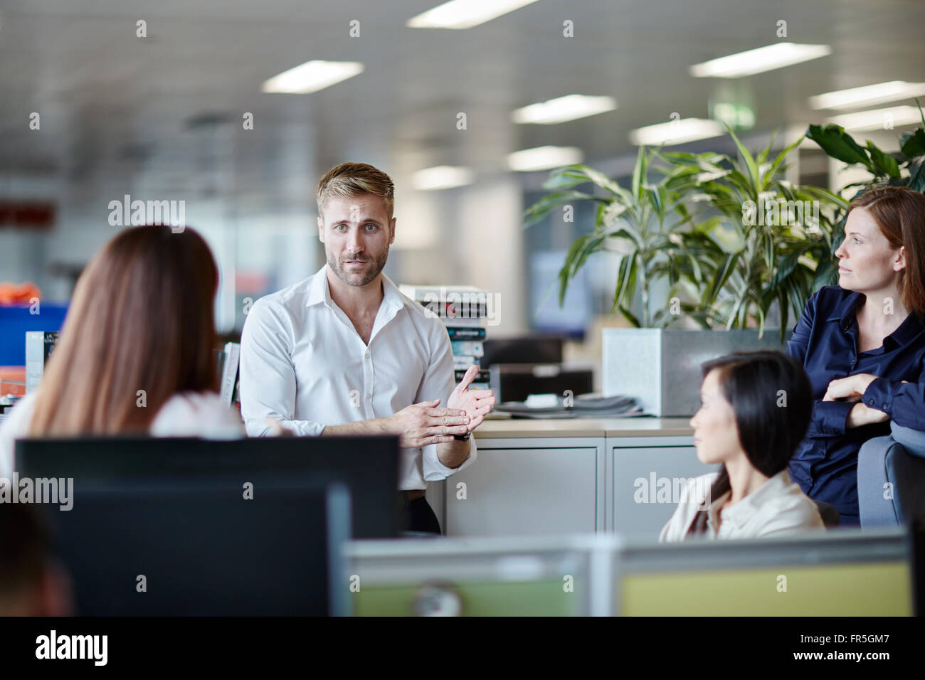 Businessman leading meeting in office cubicle Stock Photo - Alamy