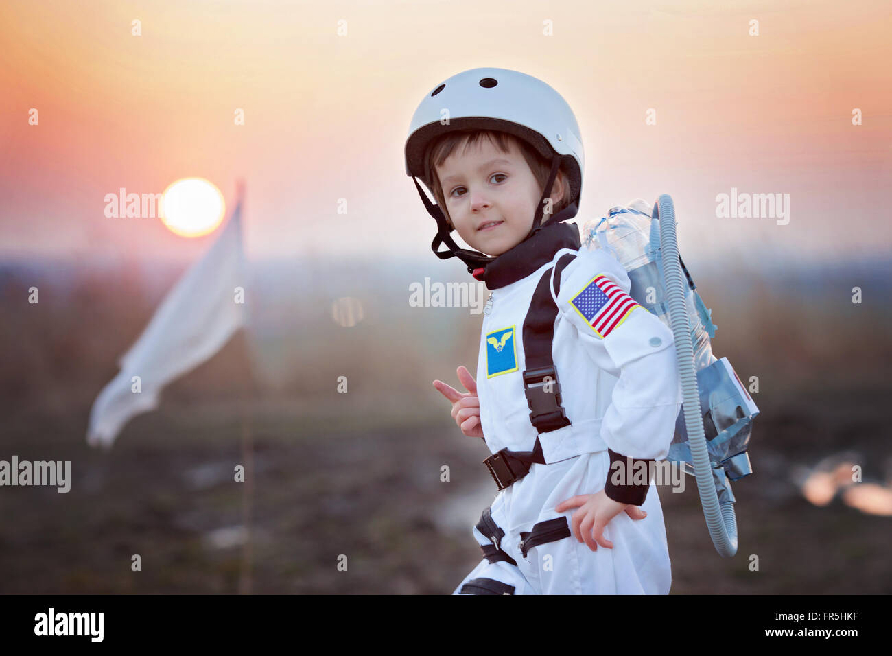 Adorable little boy, dressed as astronaut, playing in the park with ...