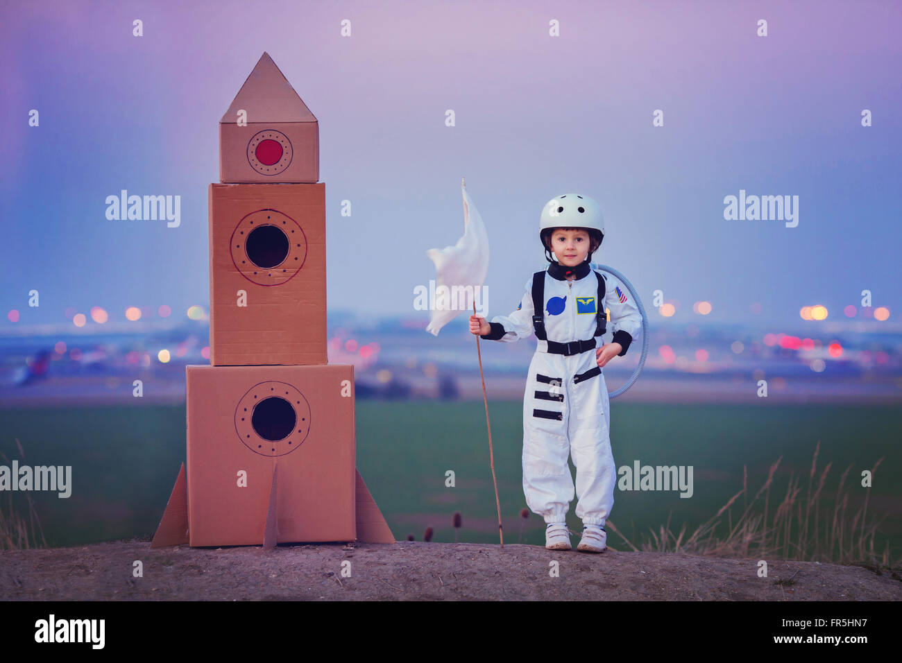Adorable little boy, dressed as astronaut, playing in the park with ...