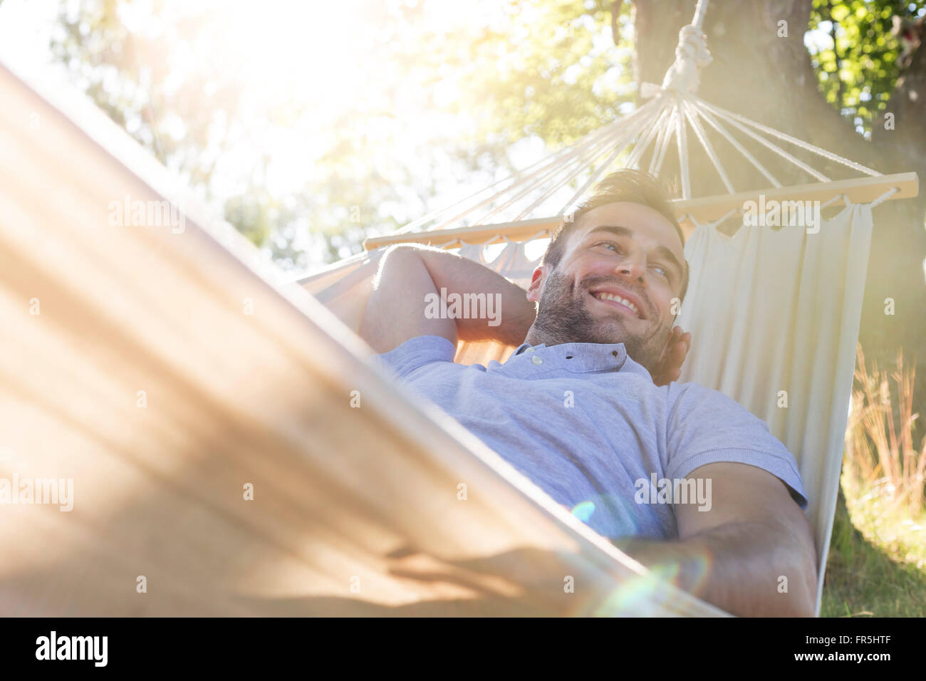Smiling young man relaxing in summer hammock Stock Photo - Alamy