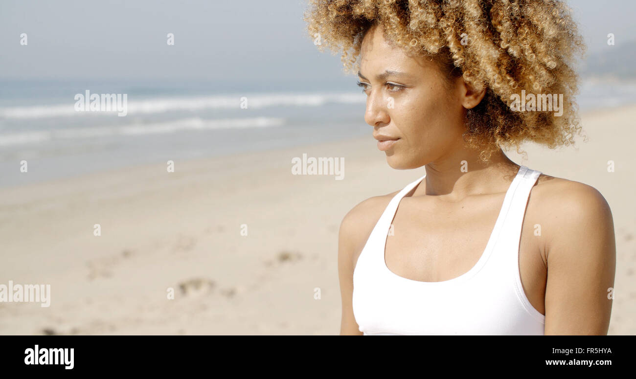 African woman wearing a white bikini tanning on the beach Stock Photo ...