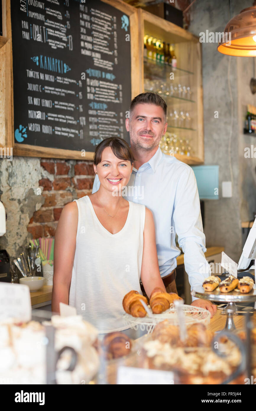 Portrait smiling cafe owner couple behind the counter Stock Photo - Alamy