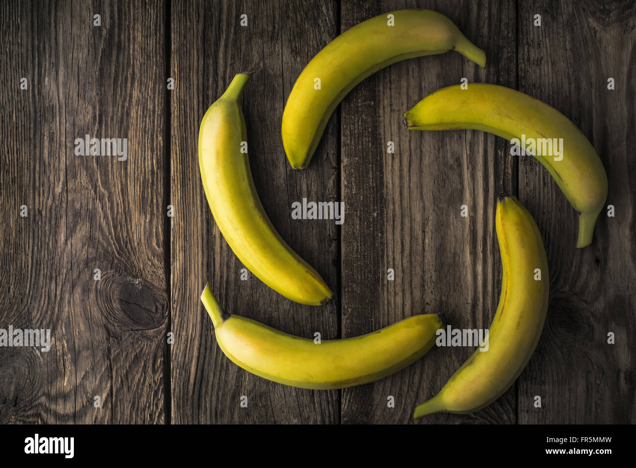 Green bananas on an old wooden table horizontal Stock Photo - Alamy