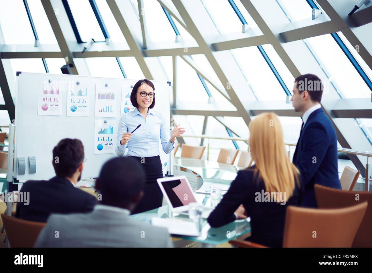 Young employee giving a presentation to business people Stock Photo - Alamy