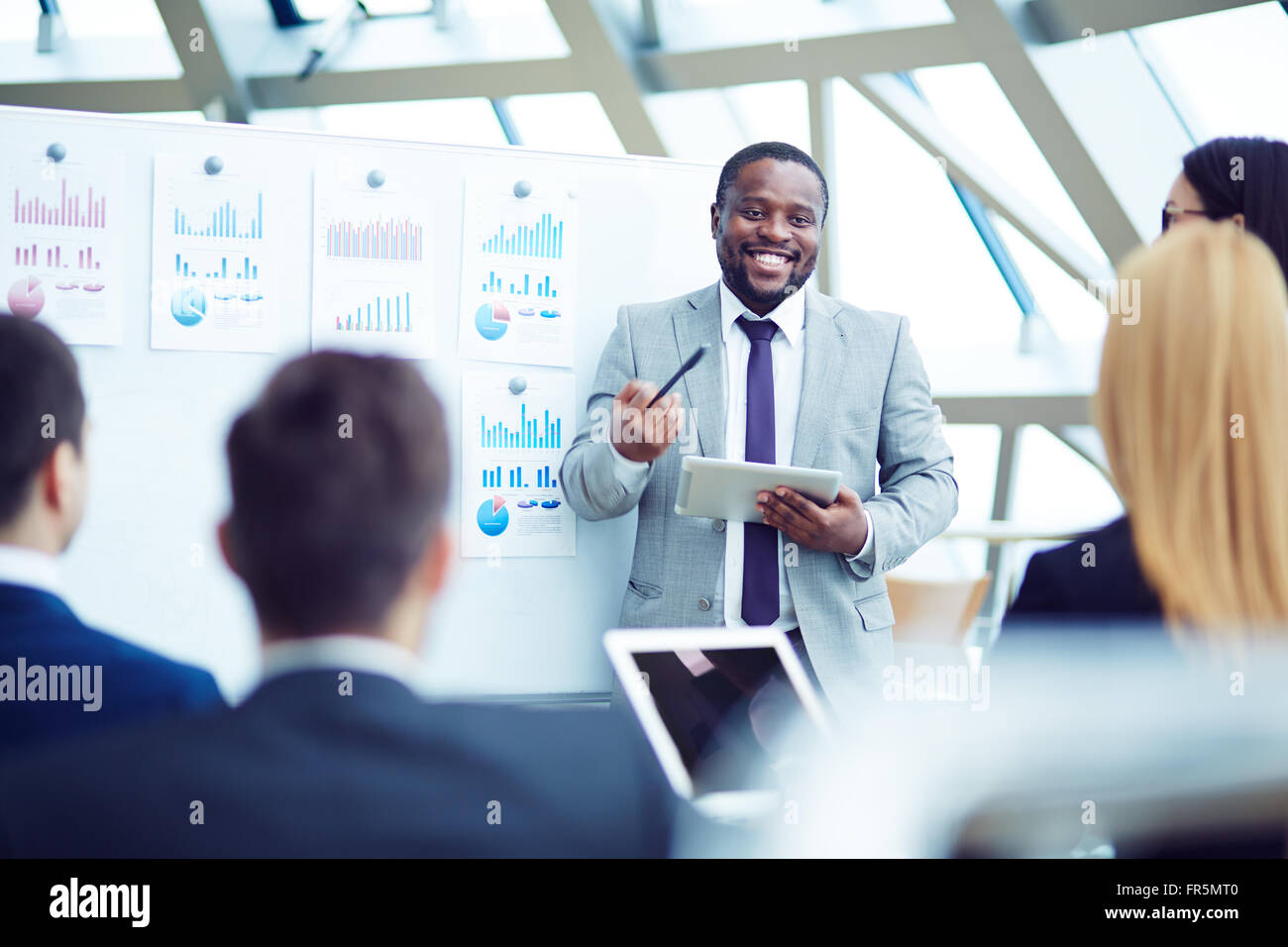 Smiling African businessman explaining project to his colleagues Stock ...