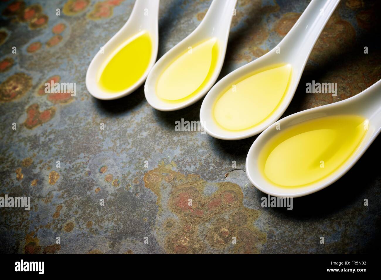 Olive oil in a small china spoons Stock Photo - Alamy