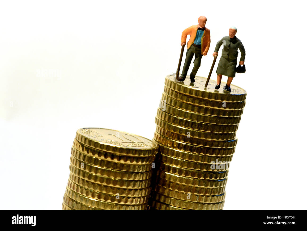 ILLUSTRATION - Model figures of a retired couple standing on a stack of ...