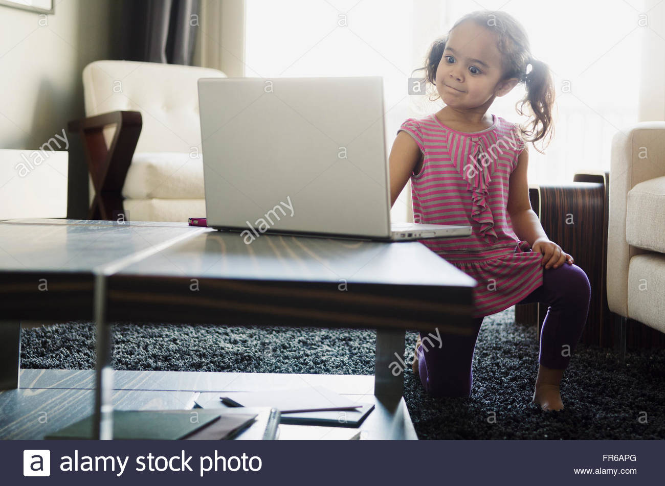 perplexed young girl looking at laptop Stock Photo - Alamy