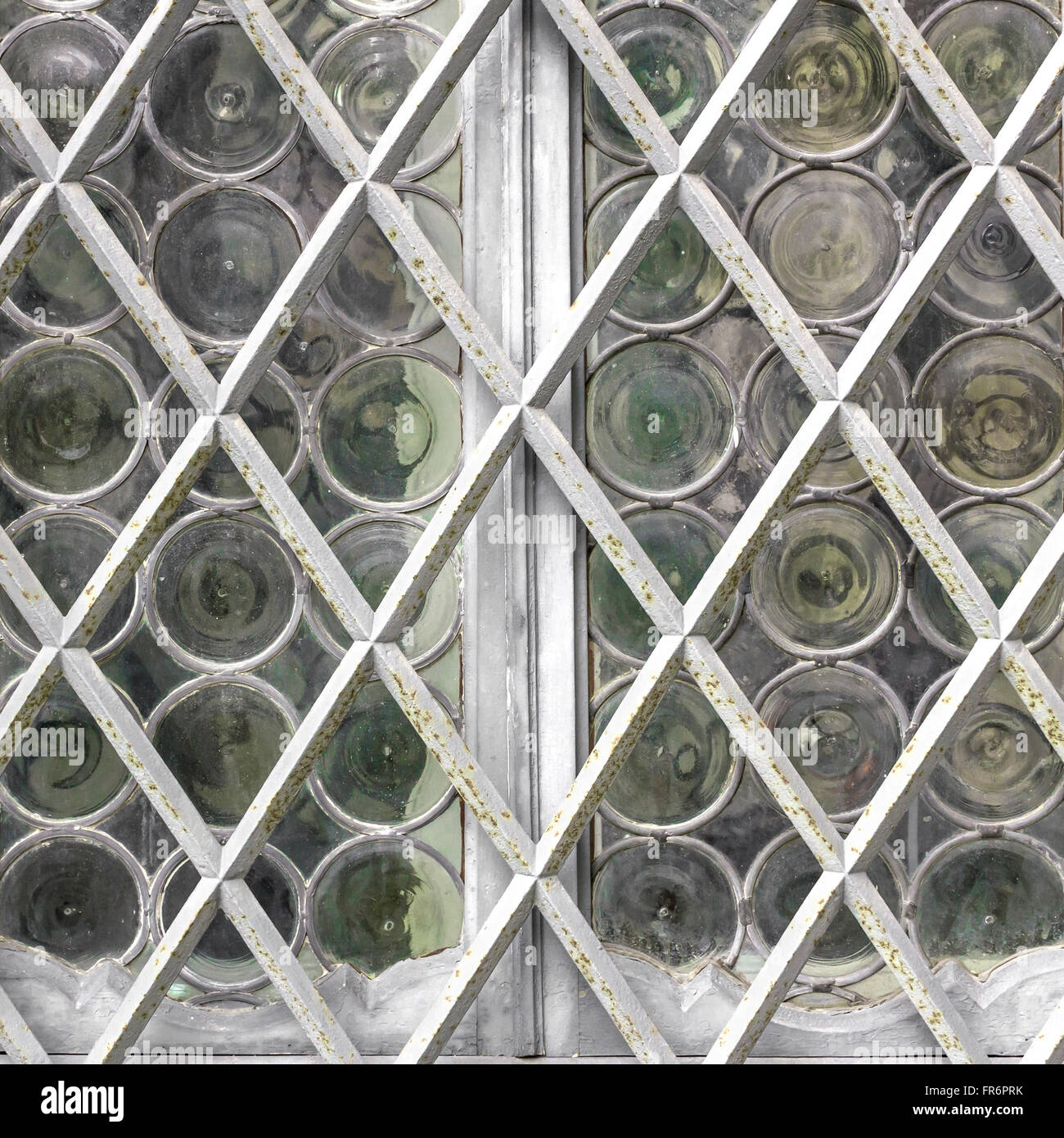 Window with white grate on background of matt glass with pattern of ...