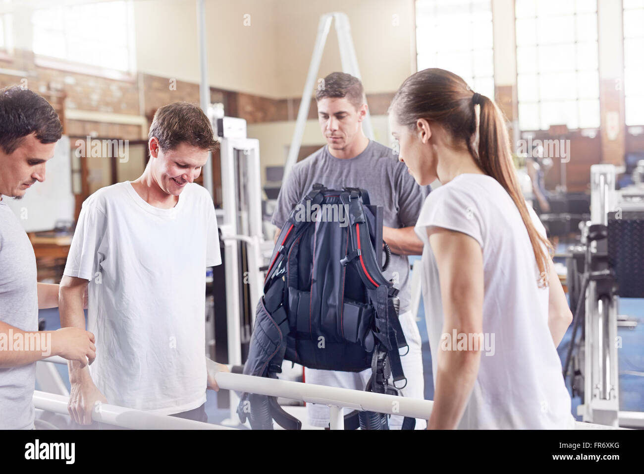 Physical therapists helping man walk Stock Photo - Alamy