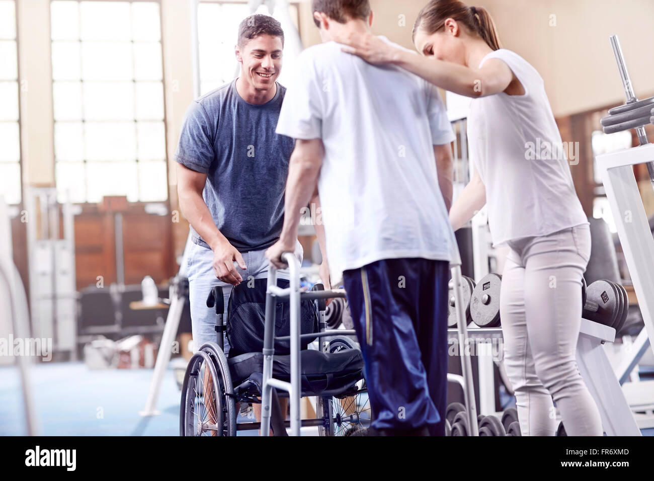 Physical therapists helping man with walker Stock Photo - Alamy