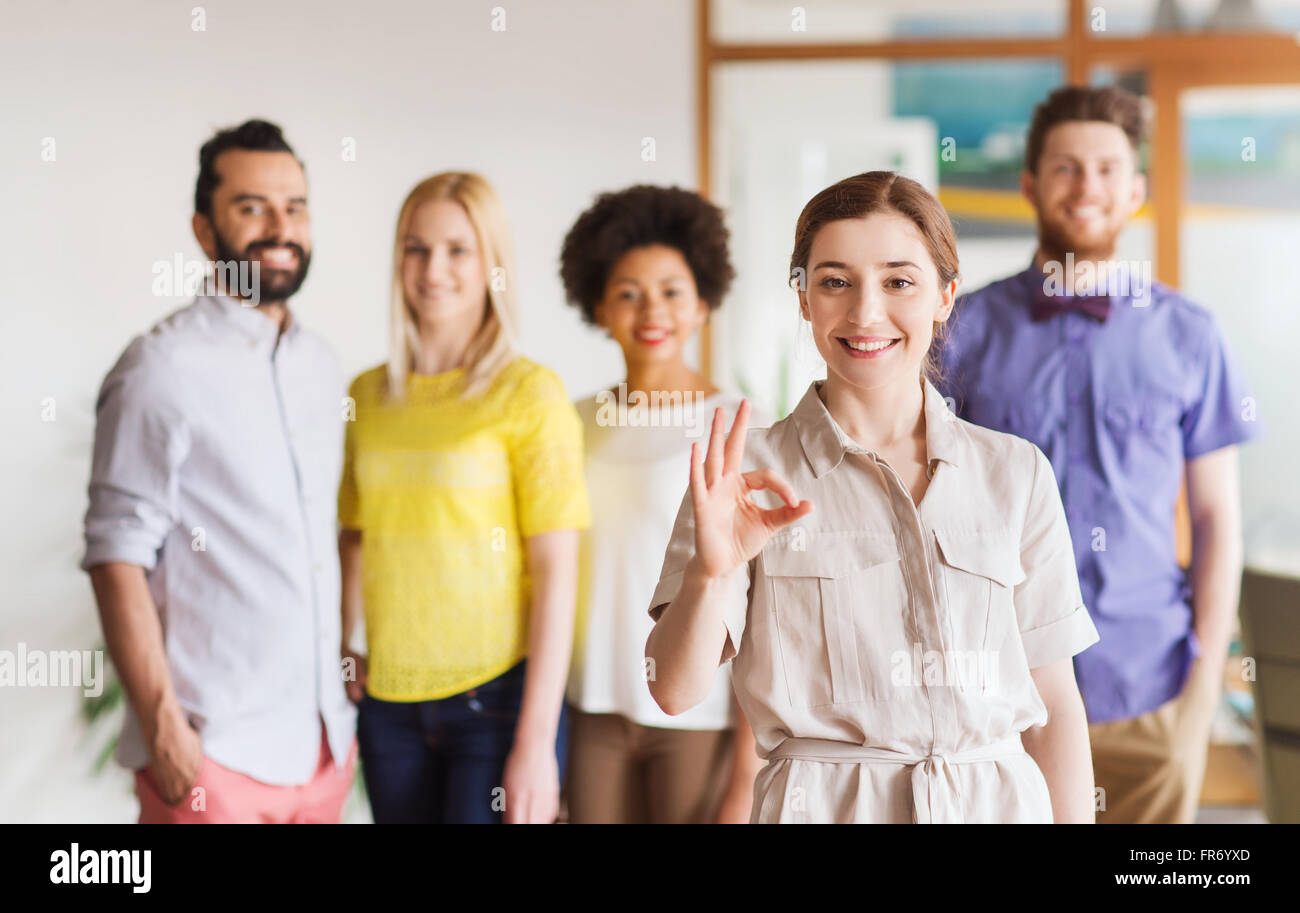 happy woman showing ok over creative office team Stock Photo - Alamy
