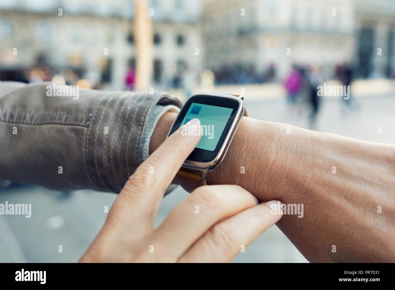Woman in the city using her smartwatch. Blur Downtown background Stock ...