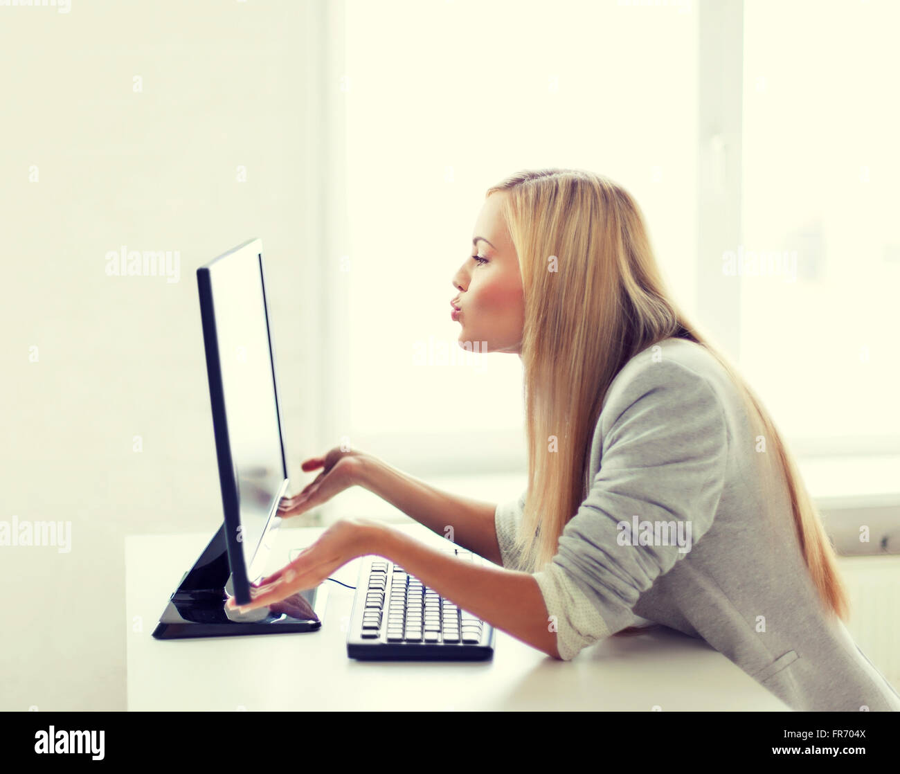 woman sending kisses with computer monitor Stock Photo - Alamy