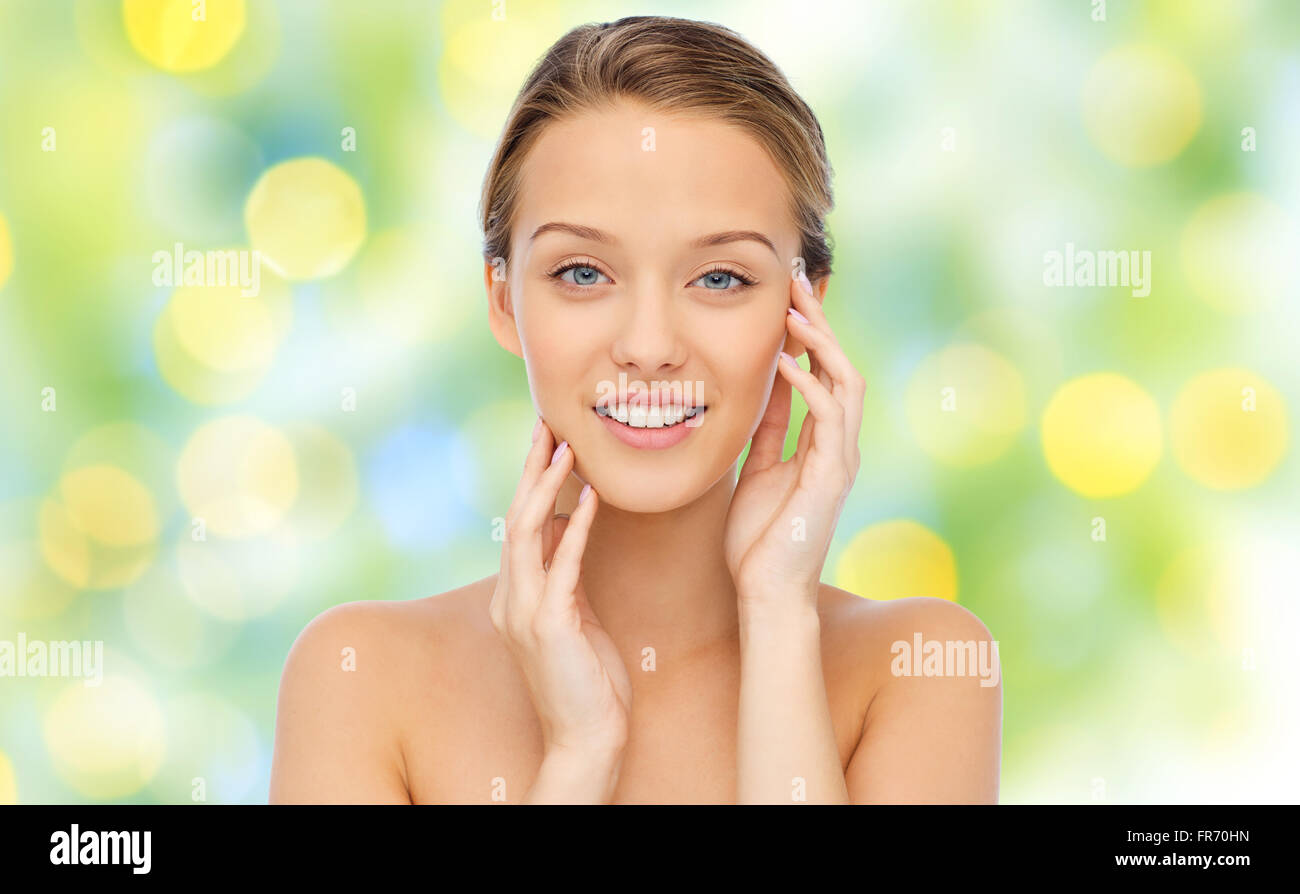 Woman touching face smiling hi-res stock photography and images - Alamy