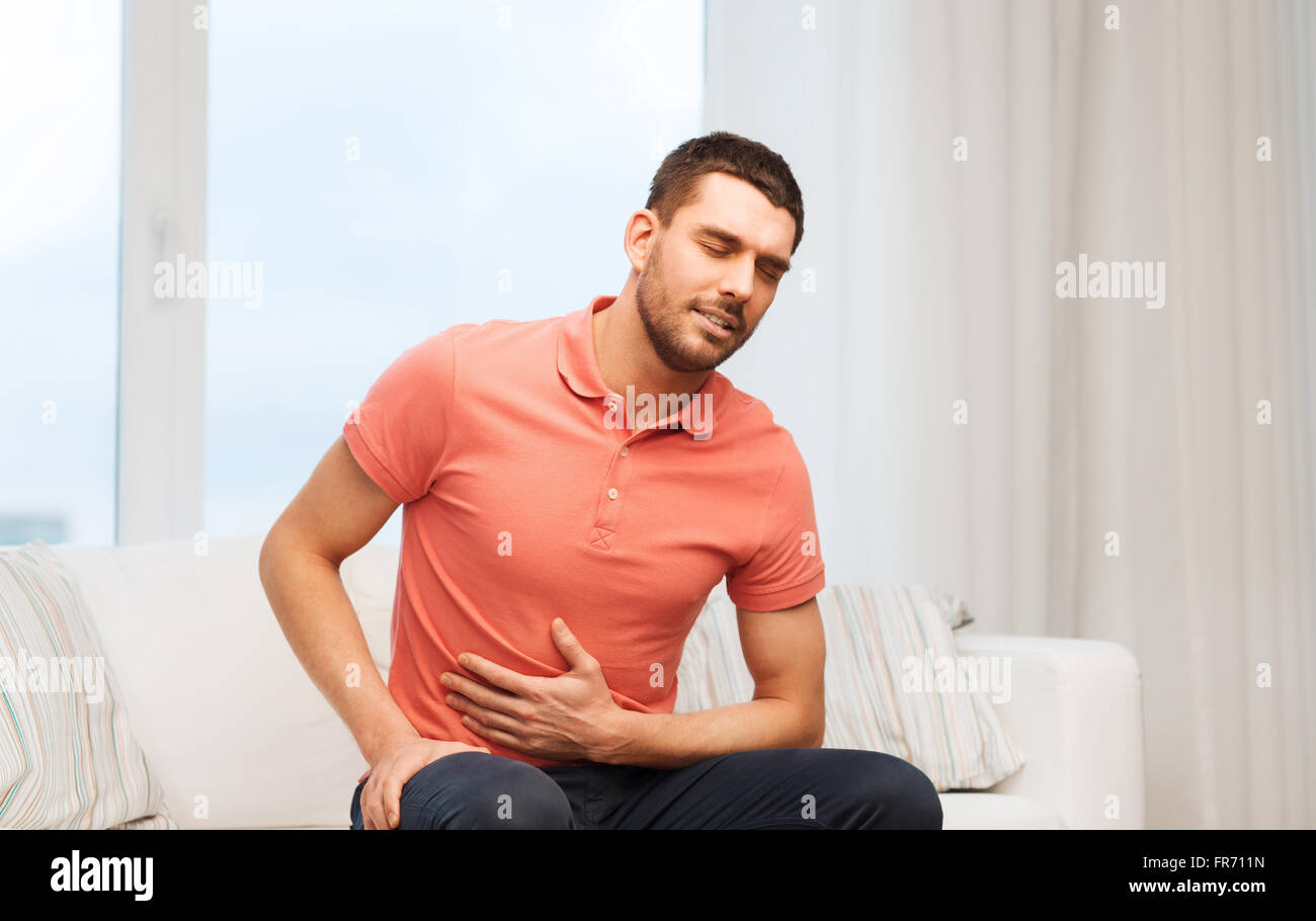 unhappy man suffering from stomach ache at home Stock Photo - Alamy