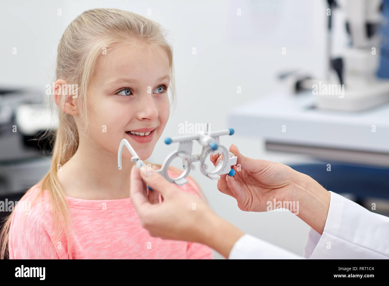 optician with trial frame and girl at clinic Stock Photo - Alamy