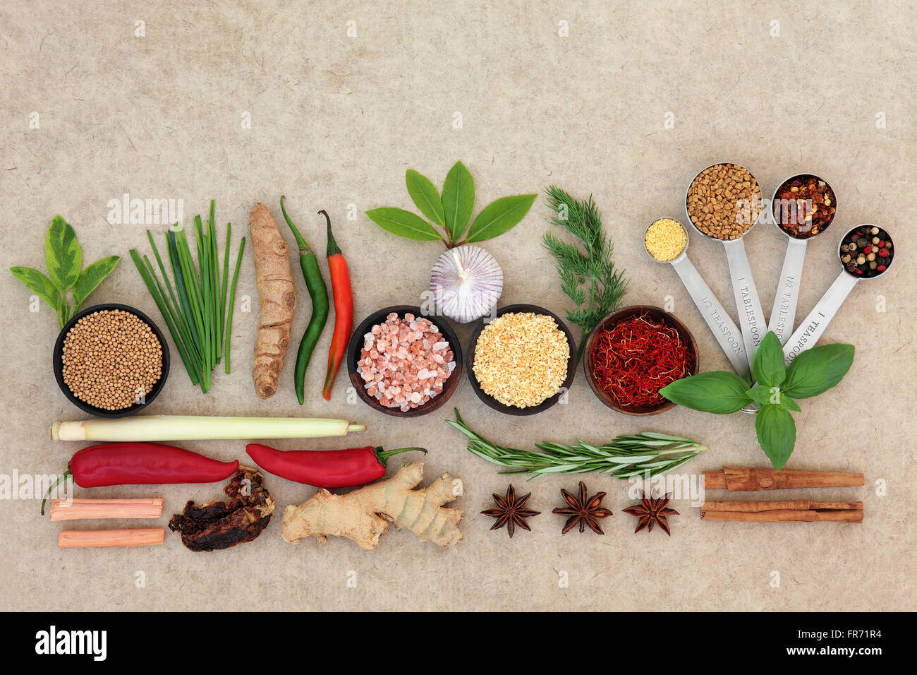 Spice and herb selection with measuring spoons forming an abstract ...