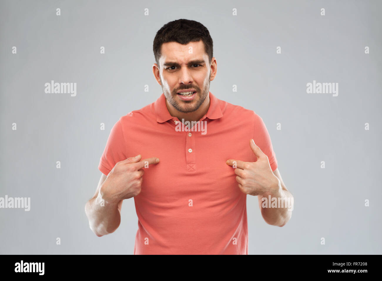 angry man pointing finger to himself over gray Stock Photo - Alamy