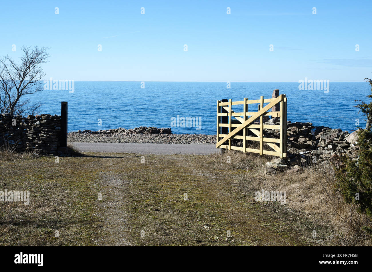 Open traditional wooden farm gate by the coast at the Swedish island ...