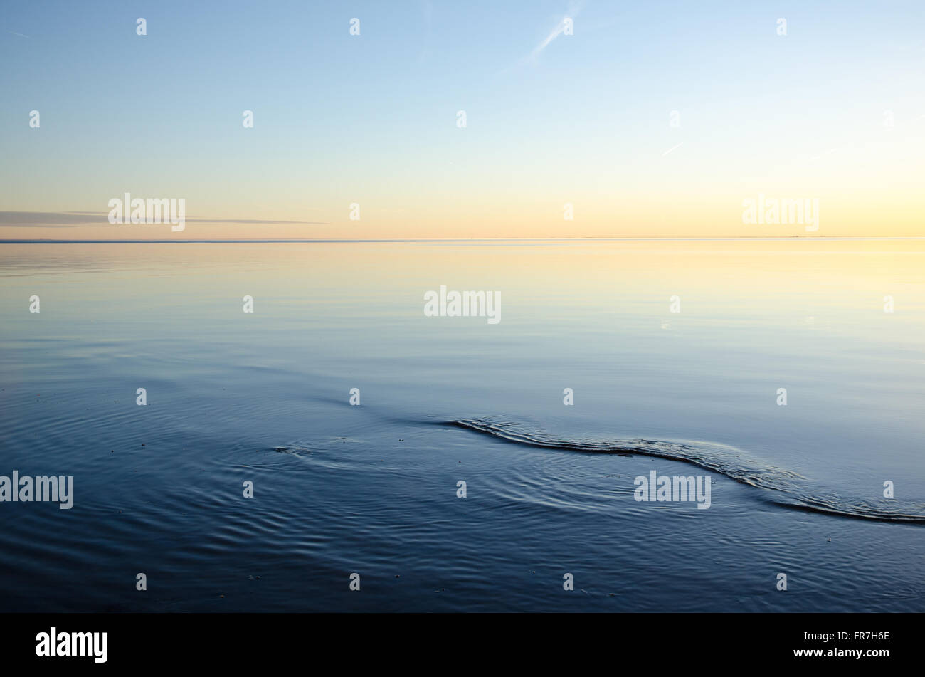 Bright colored sky and smooth colored calm blue water Stock Photo - Alamy