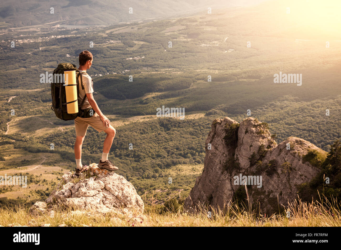 Backpacker on rock and looking at the big valley Stock Photo - Alamy