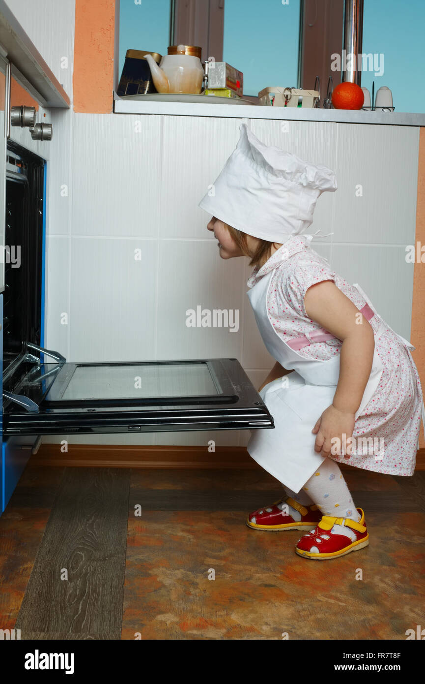 little cute chef cooking in the oven Stock Photo - Alamy