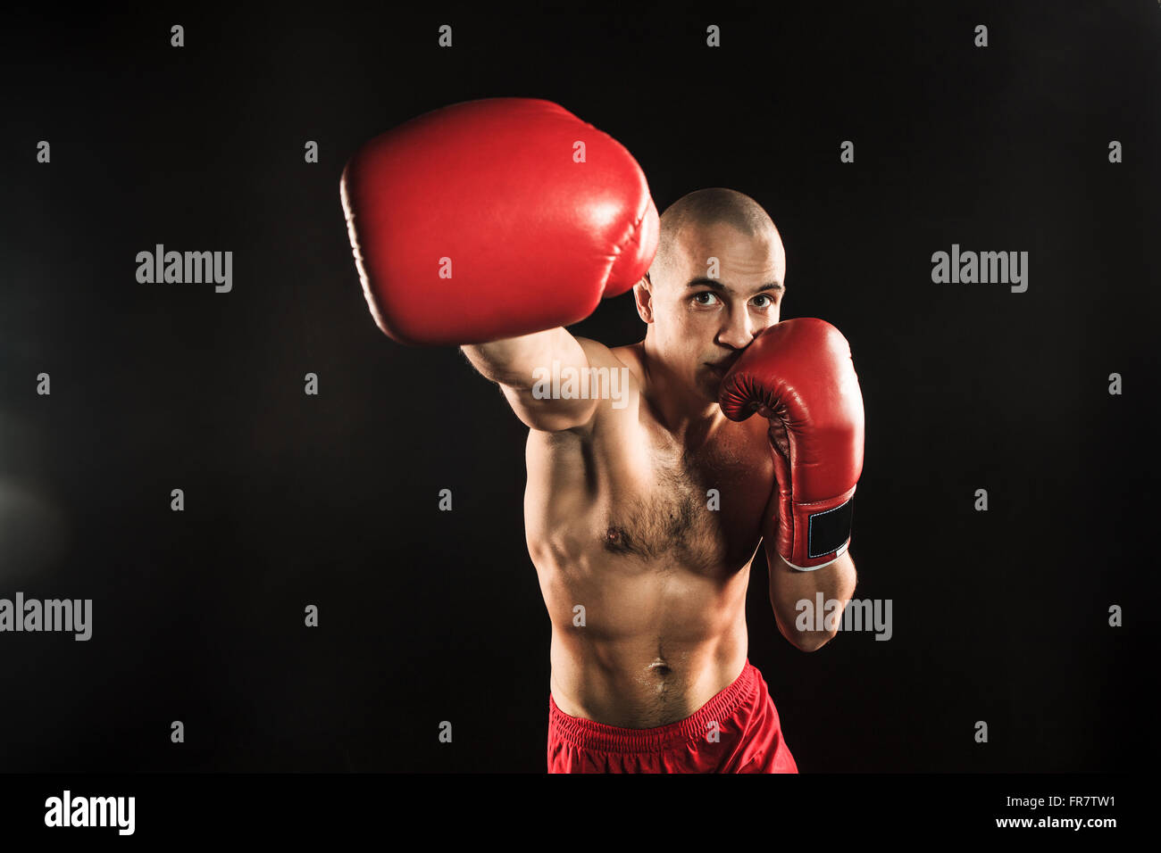 The young man kickboxing on black Stock Photo - Alamy