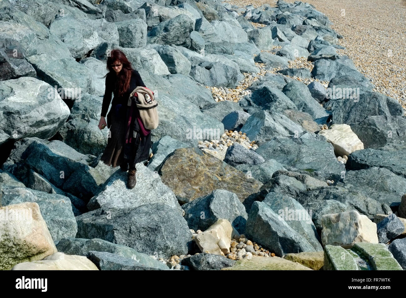 lone female walking over large rocks southsea beach england uk Stock ...