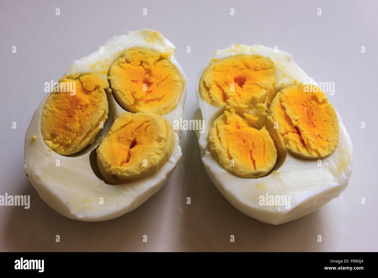 Rare boiled triple egg chicken yolk cut in half Stock Photo - Alamy