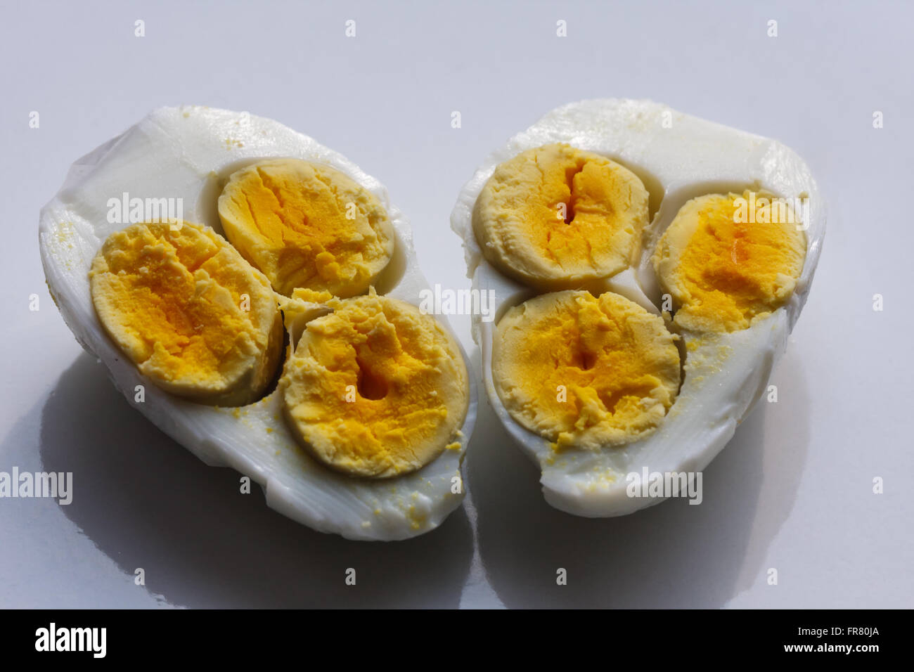 Rare boiled triple egg chicken yolk cut in half Stock Photo - Alamy